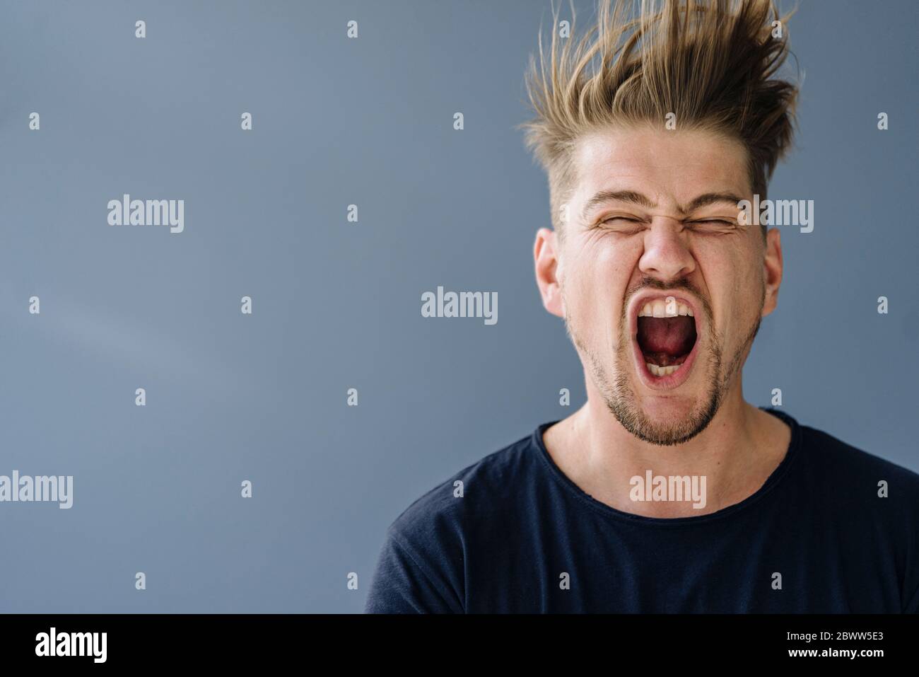 Portrait of a screaming man with tousled hair Stock Photo - Alamy