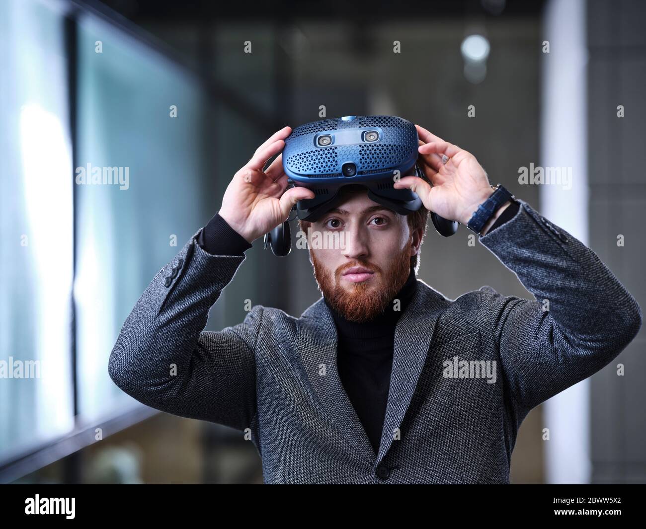 Portrait of businessman taking off VR glasses in modern office Stock ...