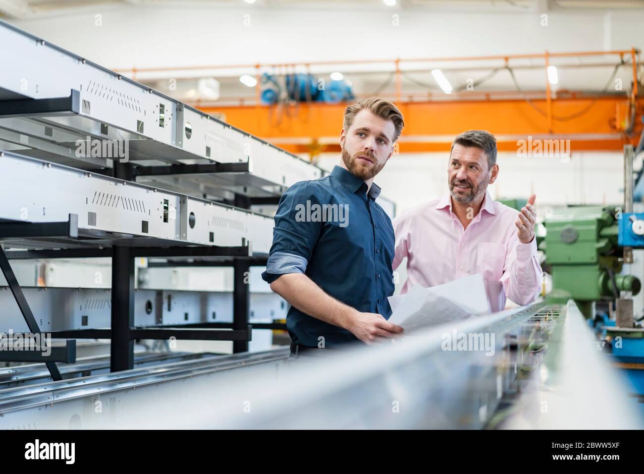 Two men having a work meeting in a factory Stock Photo - Alamy