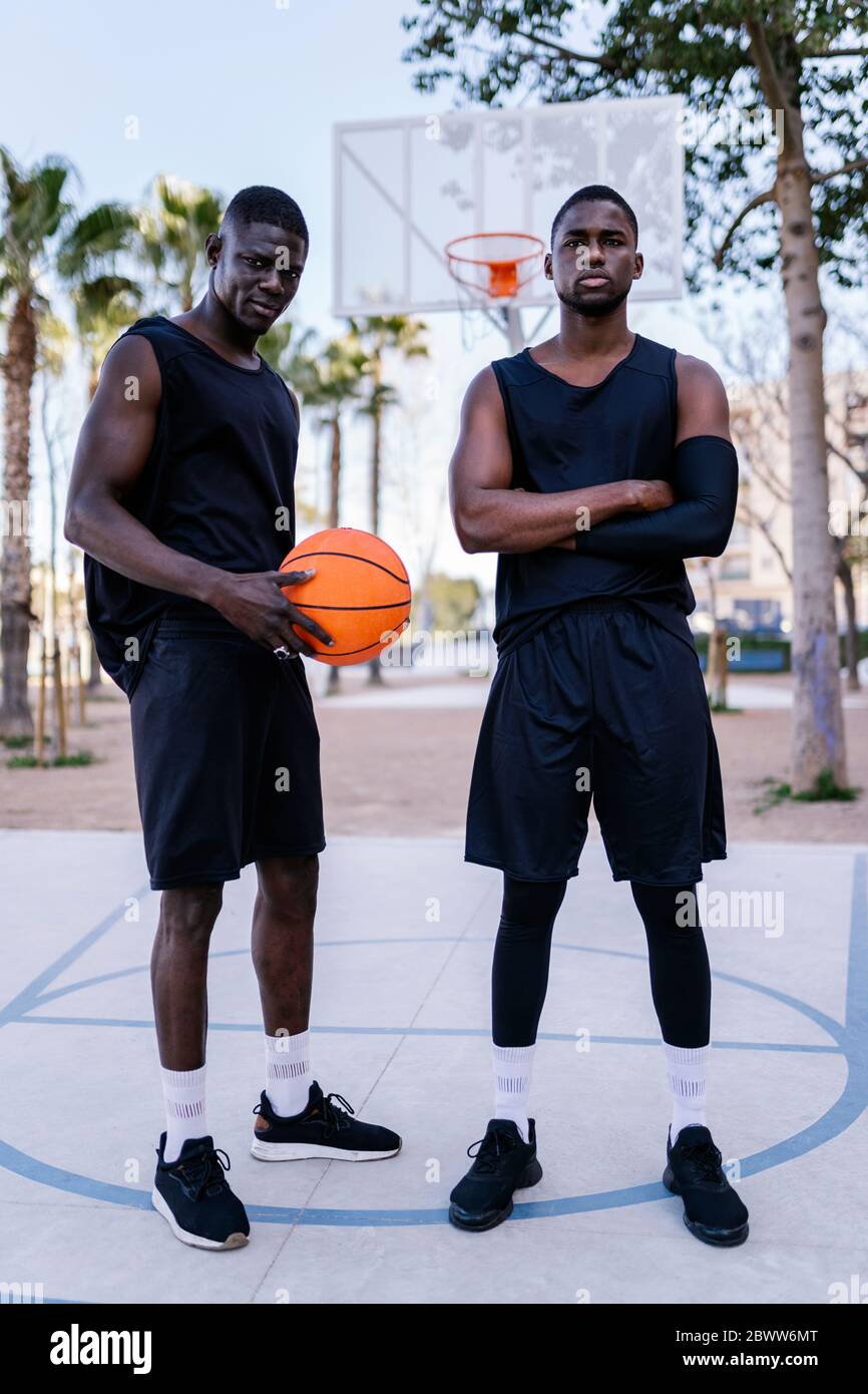 Young men with basketball on basketball court Stock Photo - Alamy