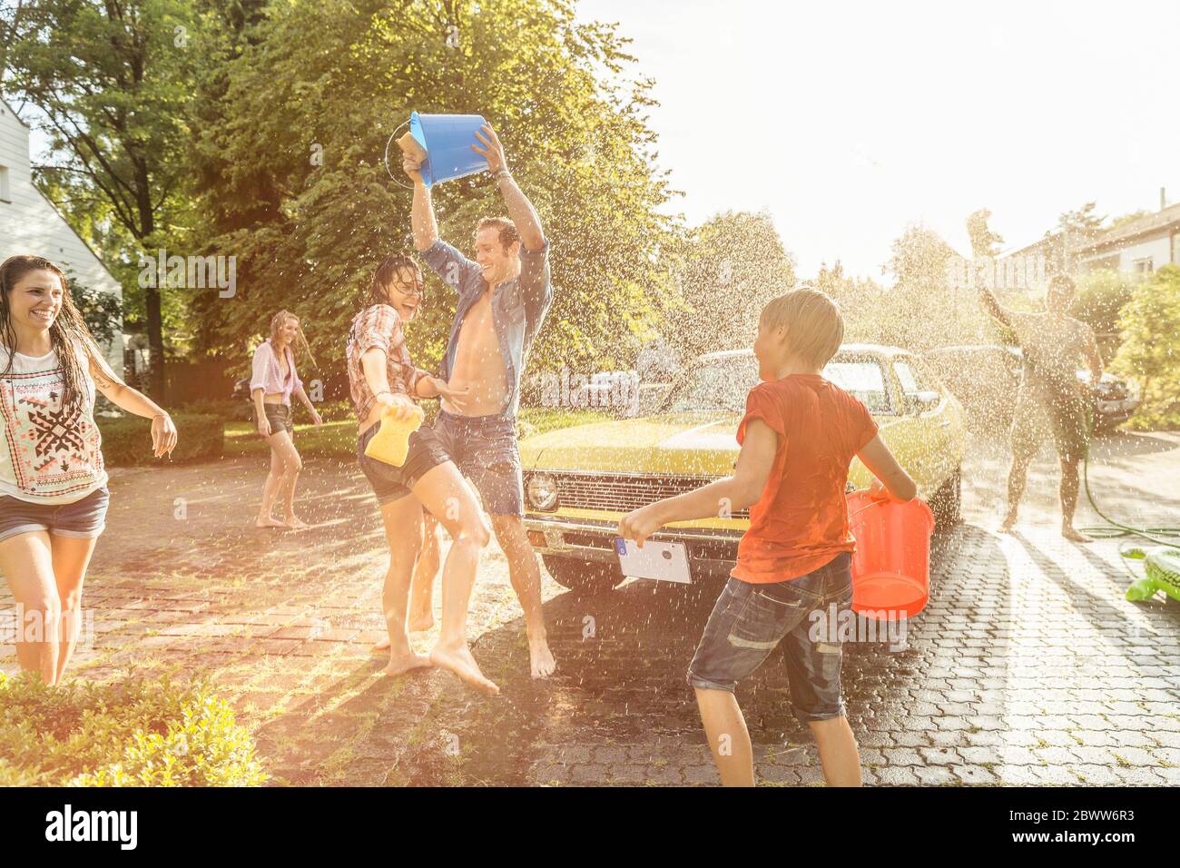 Group of friends washing yellow vintage car in summer having fun Stock ...