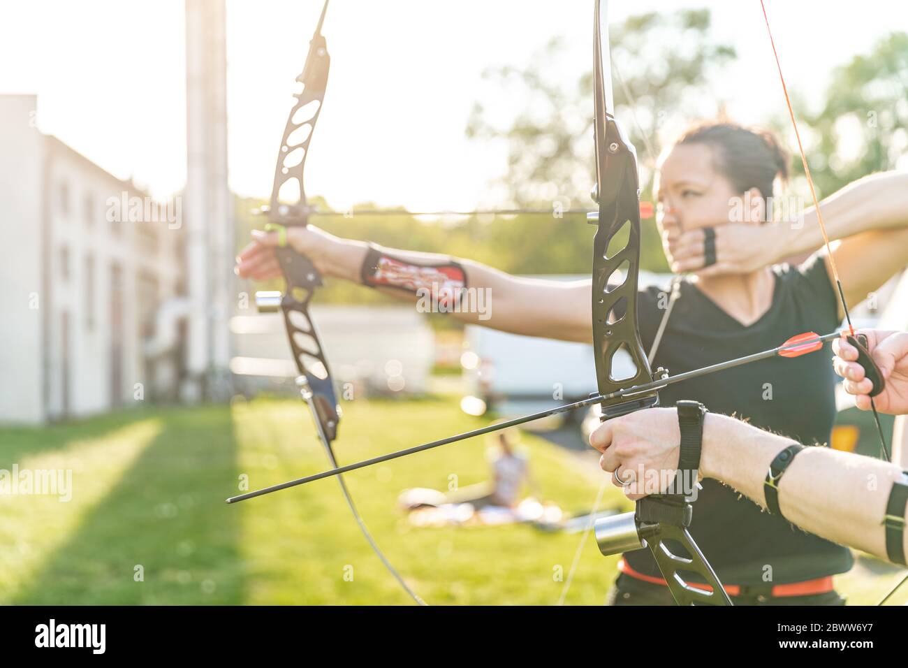 archery competition, woman preparing a bow and arrow to hit targets ...