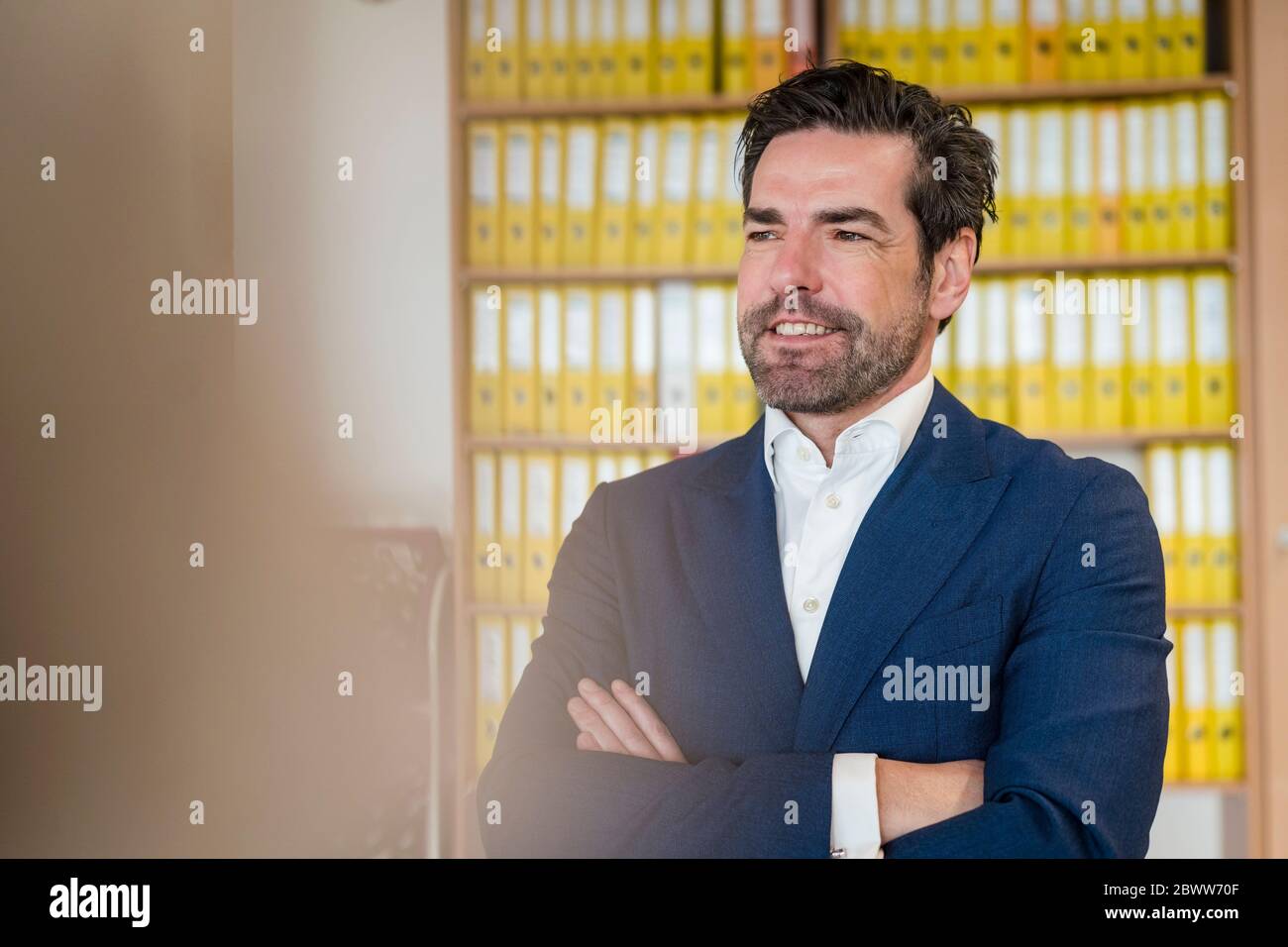 Portrait of smiling businessman at filing cabinet Stock Photo - Alamy