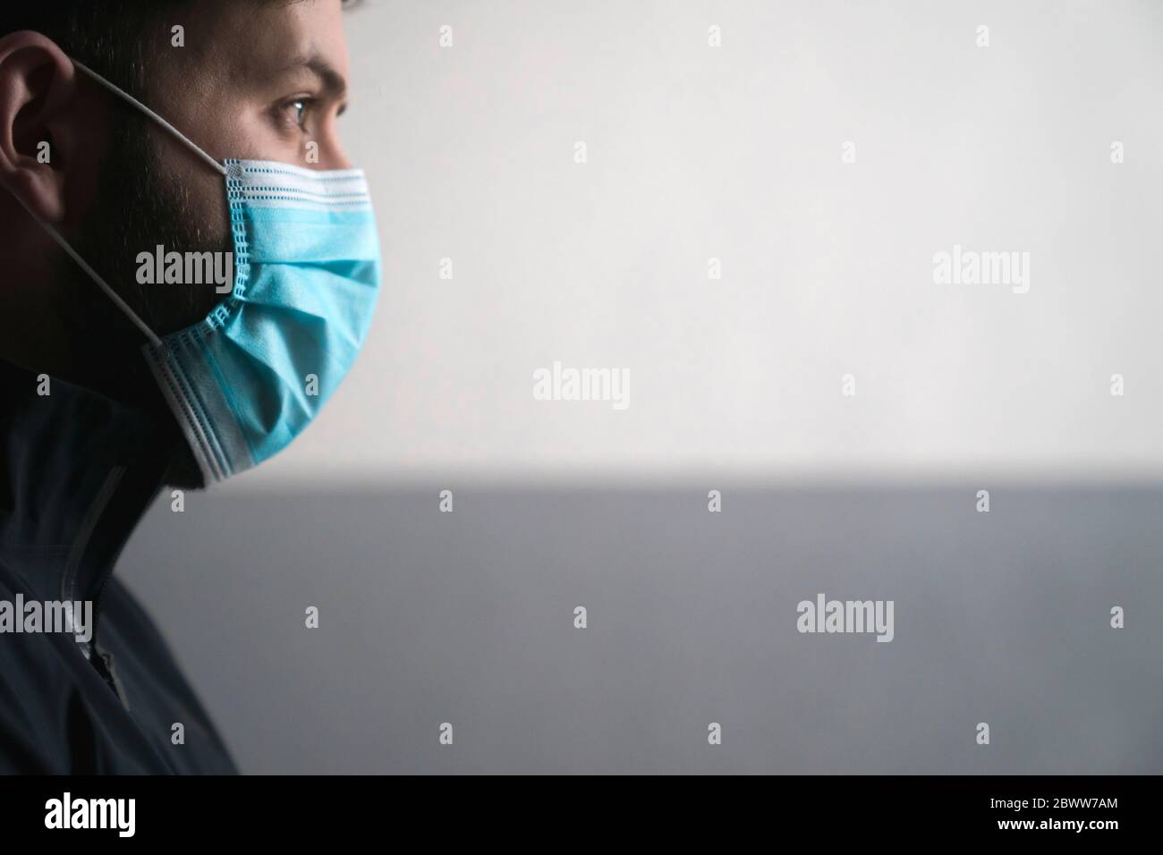 Close-up side view of thoughtful young man wearing mask Stock Photo - Alamy