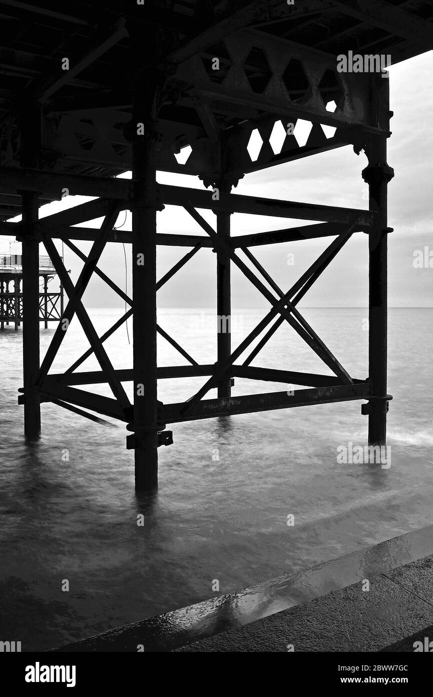 Nightfall and high tide below seaside pier Stock Photo - Alamy