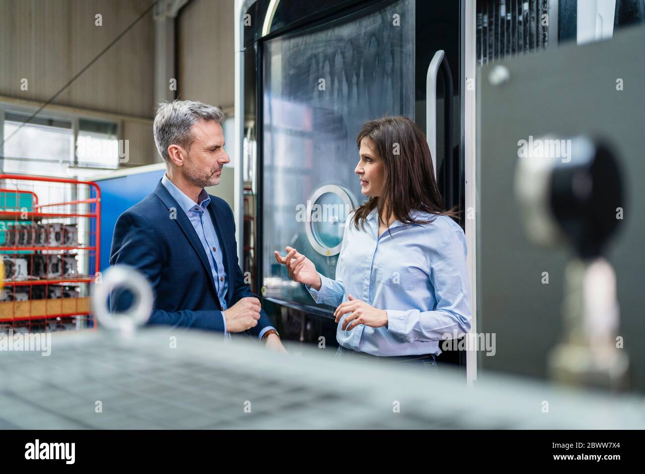 Businessman and businesswoman having a work meeting in a factory Stock ...