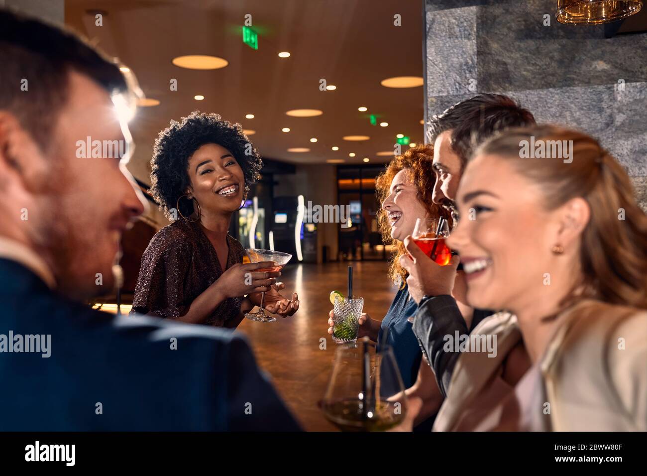 Happy friends socializing in a bar Stock Photo - Alamy