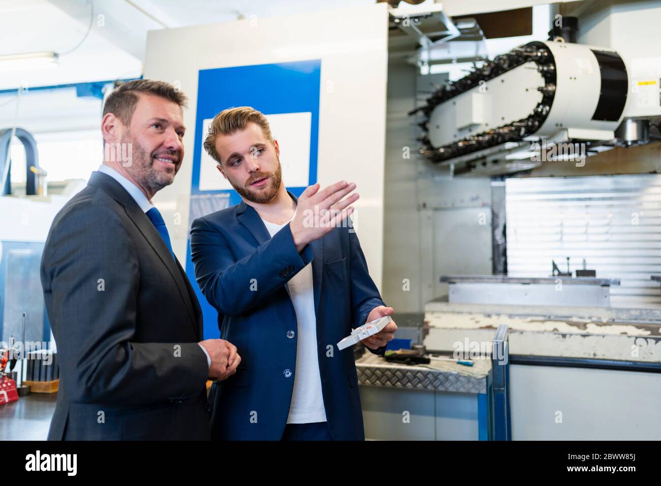 Two businessmen having a work meeting in a factory Stock Photo - Alamy