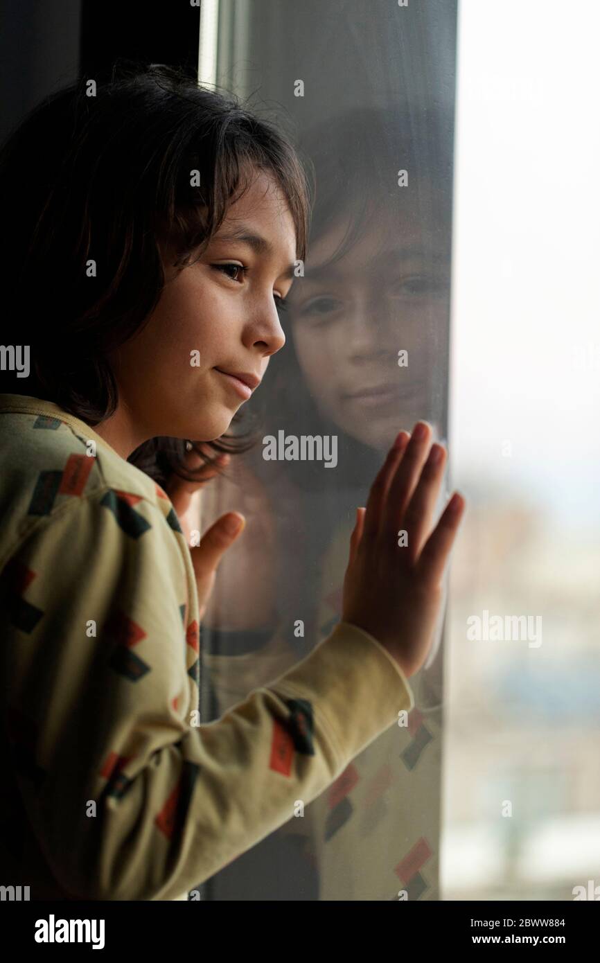 Boy looking out of window at home Stock Photo - Alamy