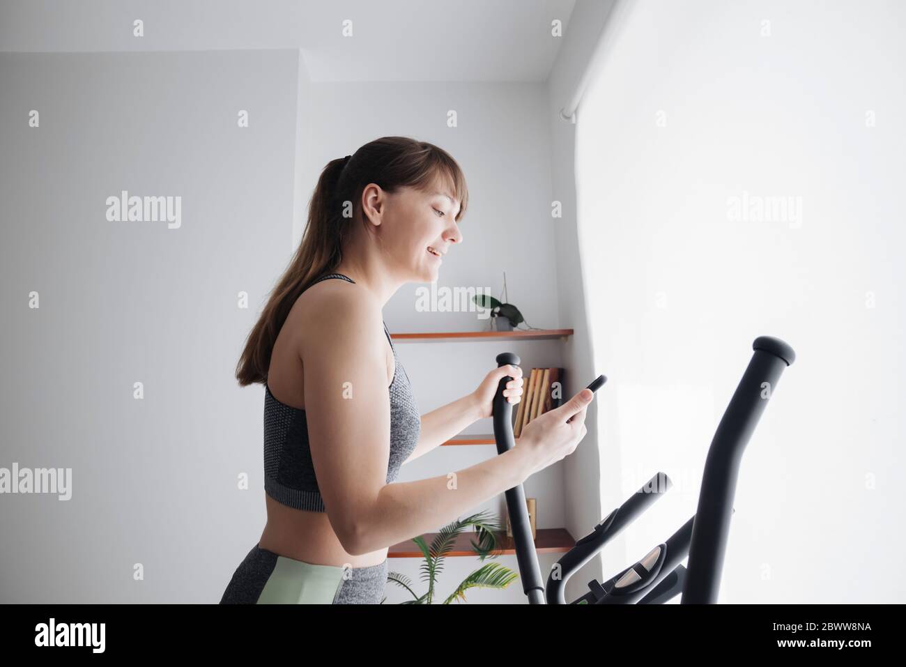 Woman training on elliptical machine hi-res stock photography and ...
