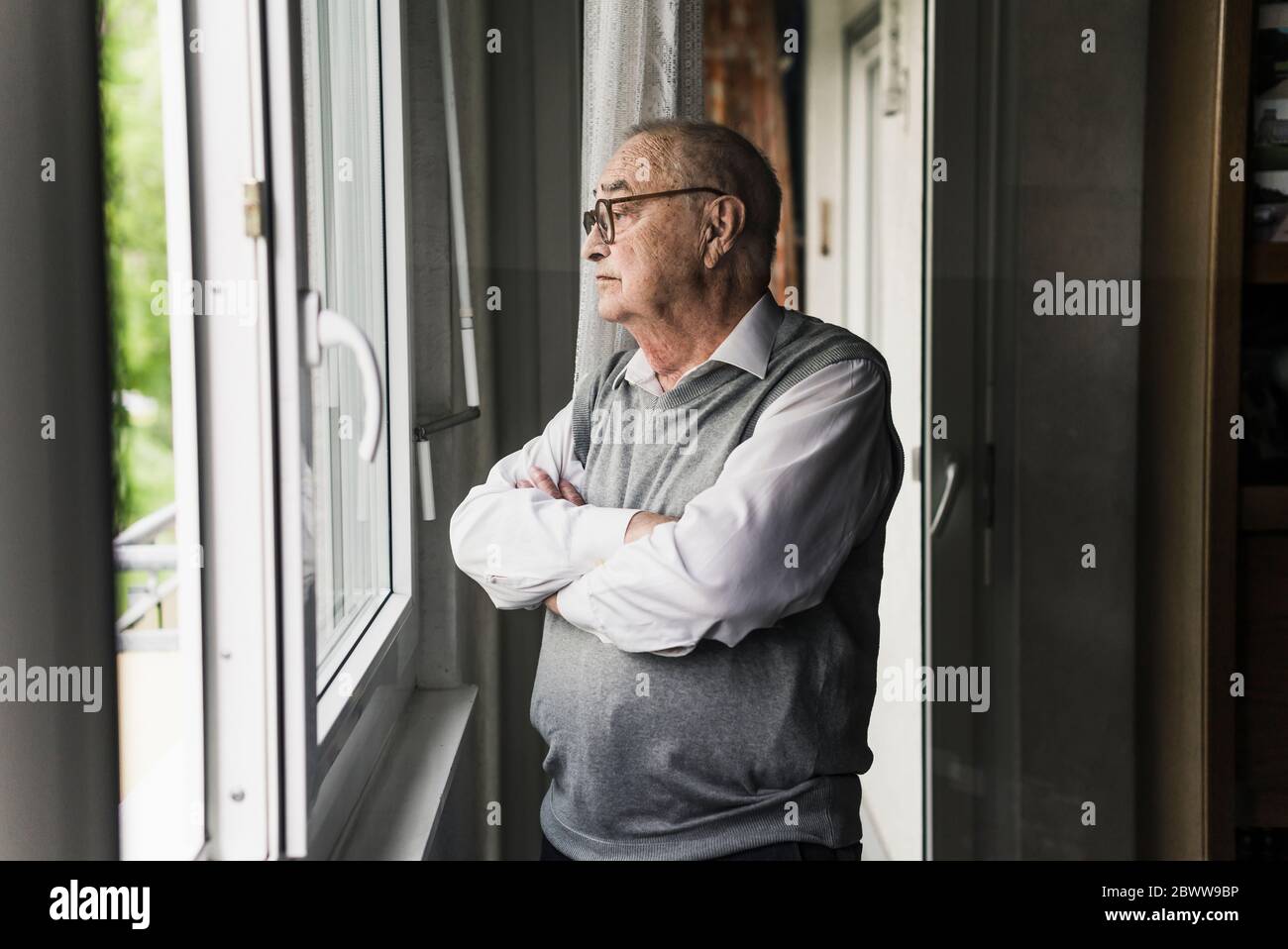 Pensive senior man looking out of window Stock Photo - Alamy