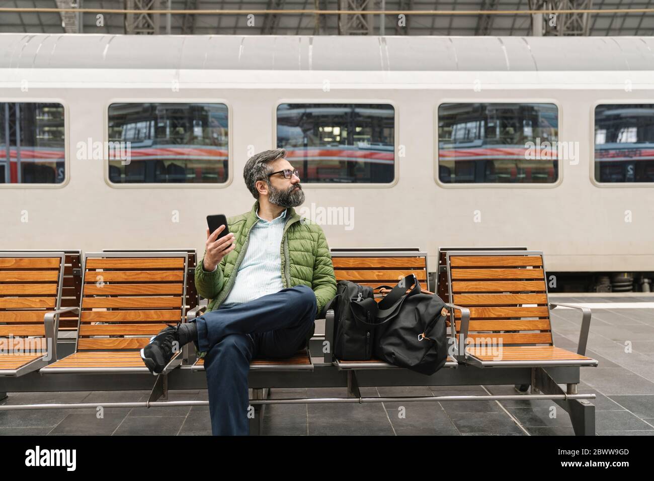 Man sitting on railway platform hi-res stock photography and images - Alamy