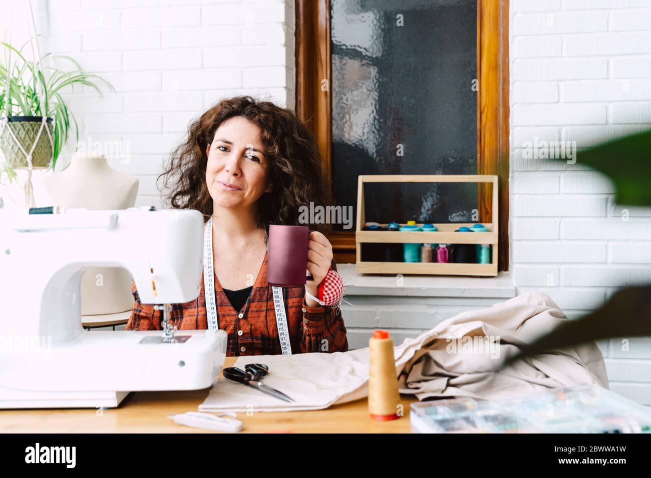 Portrait of woman sewing at home Stock Photo - Alamy