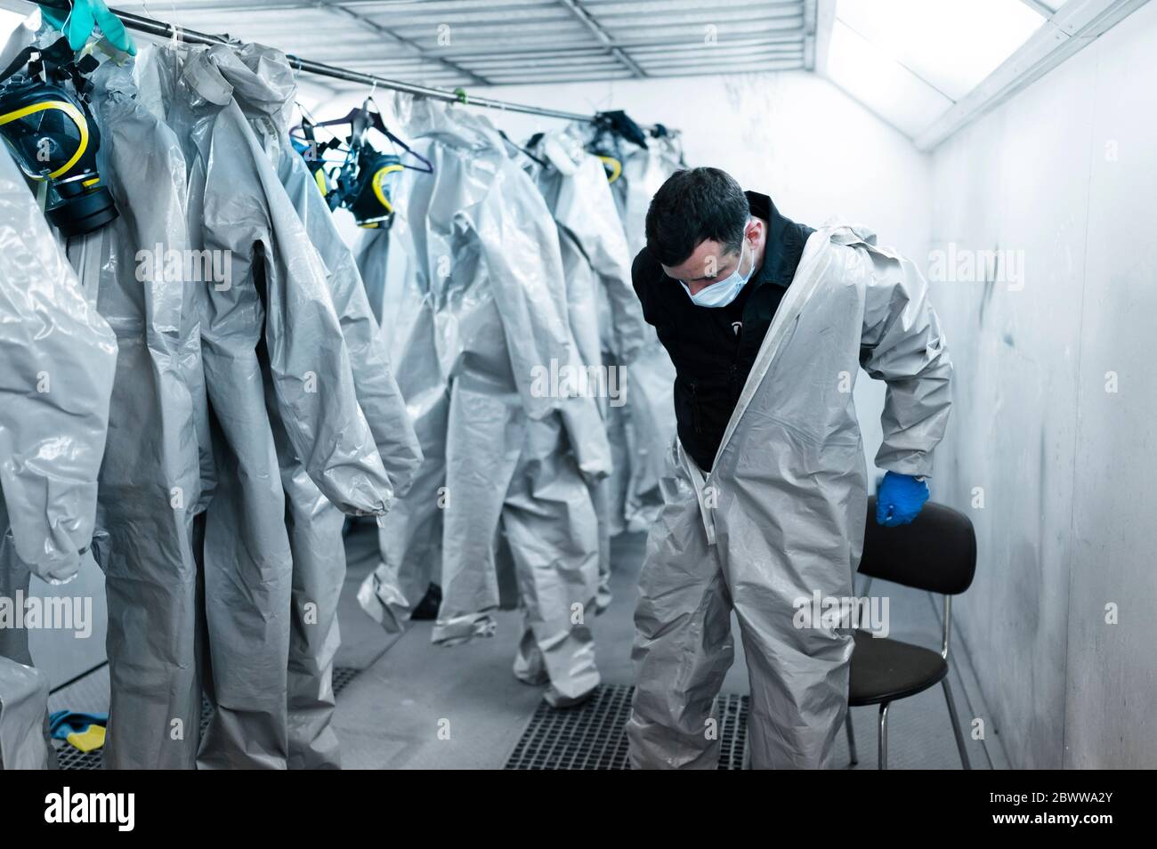Healthcare worker wearing protective suit in locker room Stock Photo ...