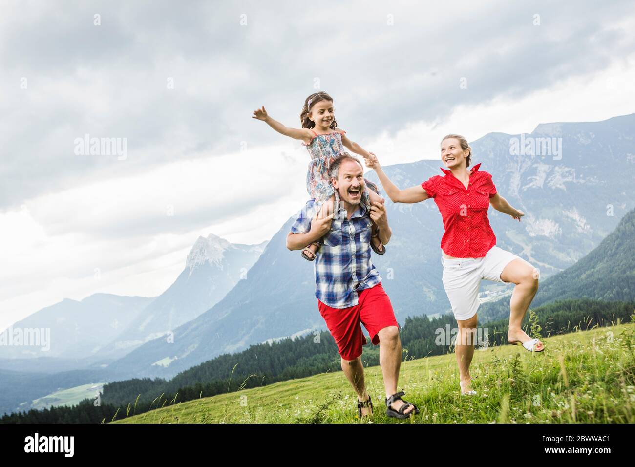 Happy family running on meadow the mountains hi-res stock photography ...