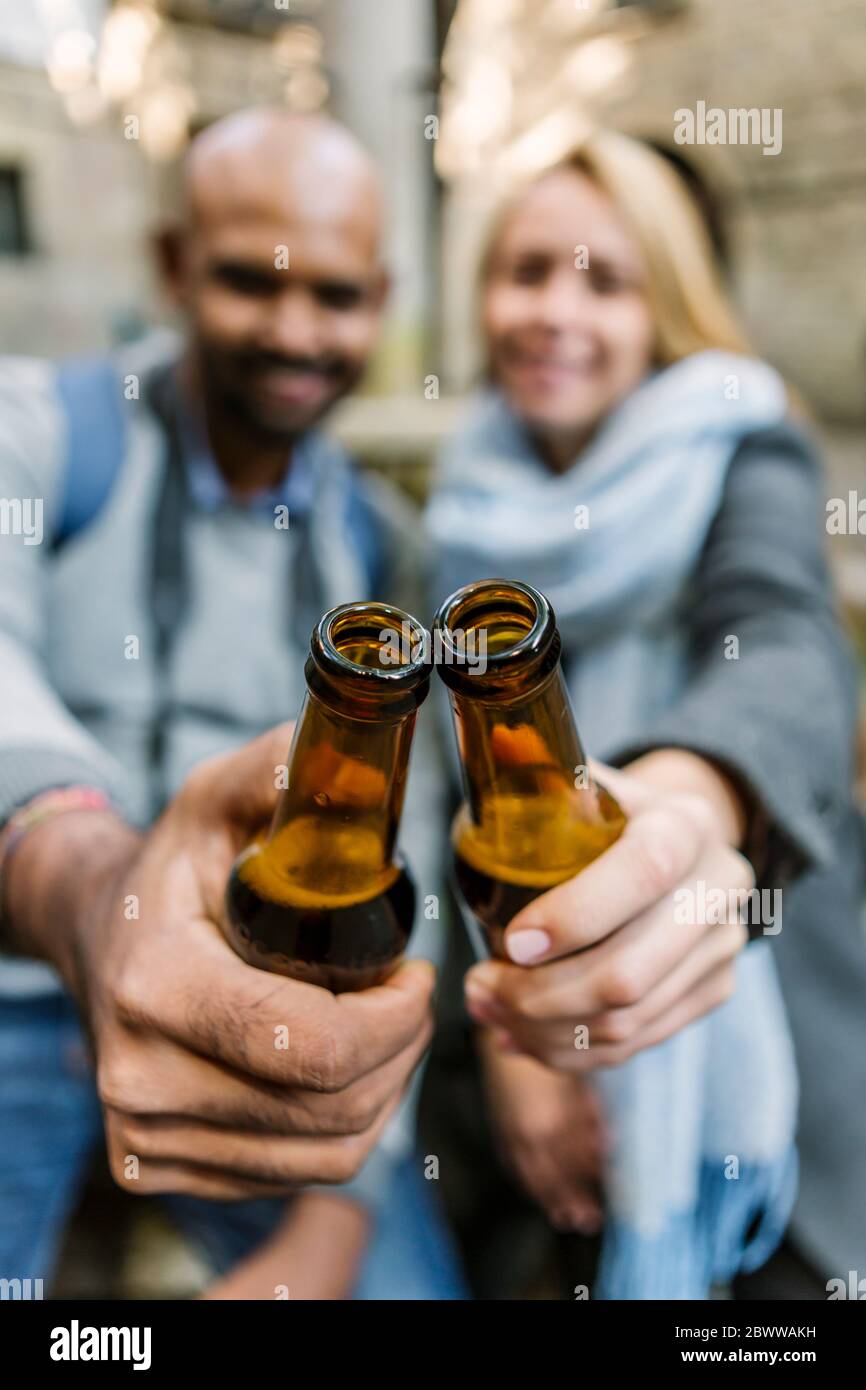 Couple toasting with beer bottles, Barcelona, Spain Stock Photo - Alamy