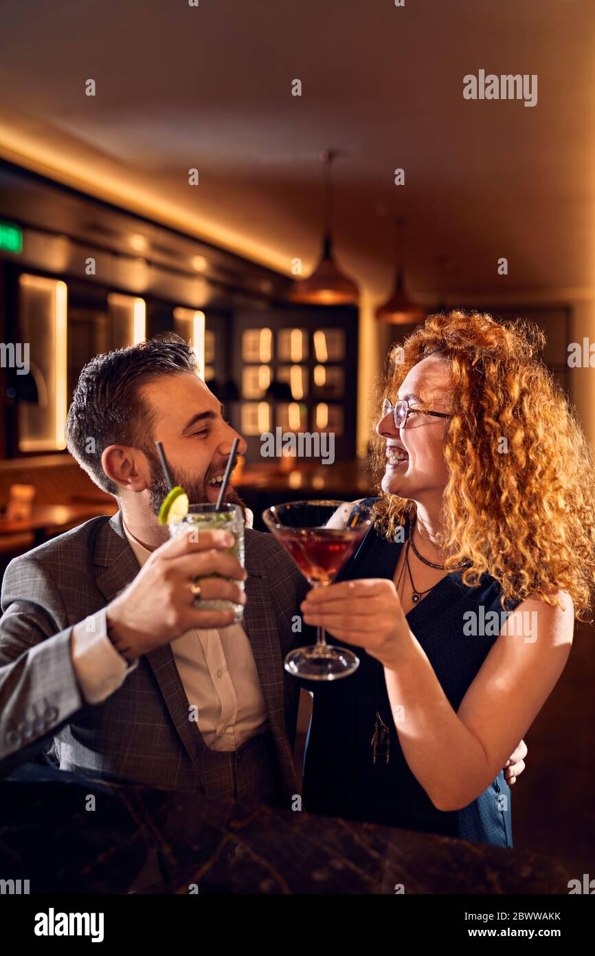 Happy couple socializing in a bar Stock Photo - Alamy