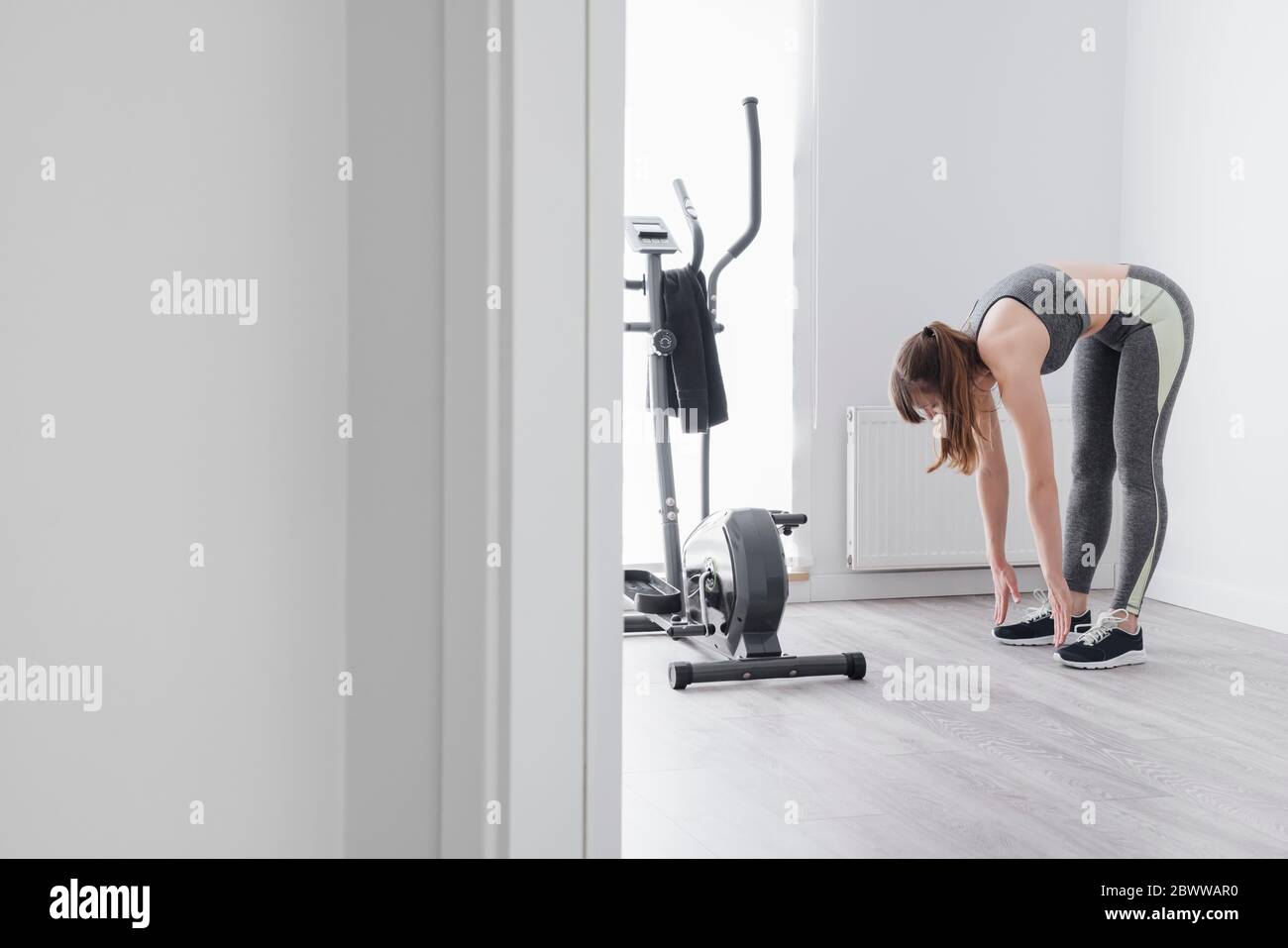 Woman performing stretching exercises before a workout at home Stock ...