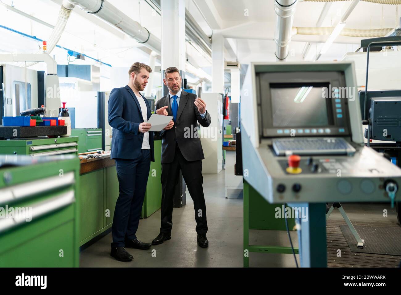 Two businessmen having a work meeting in a factory Stock Photo - Alamy