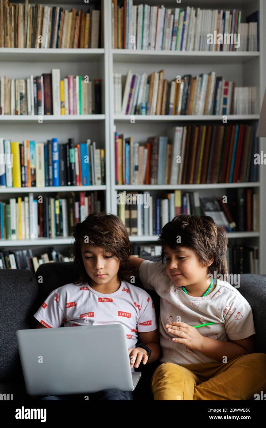 Two boys using laptop home hi-res stock photography and images - Alamy