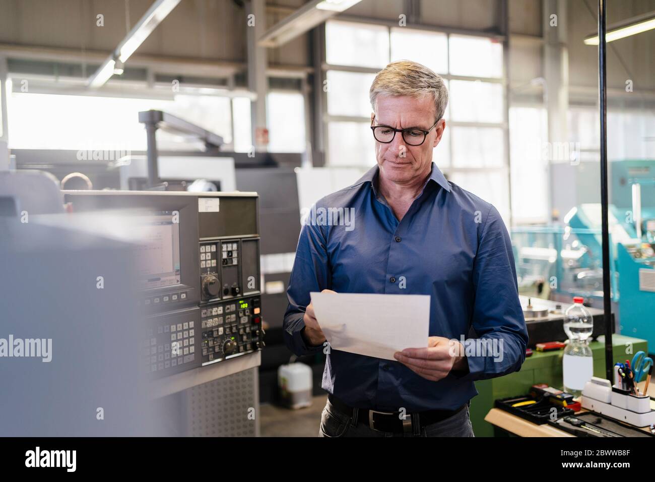 Senior employee checking production plans Stock Photo - Alamy