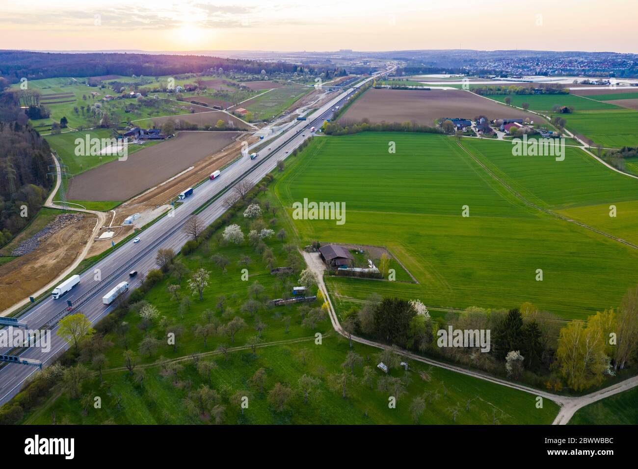 Germany, Baden-Wurttemberg, Kongen, Aerial view of countryside highway at springtime sunset ...