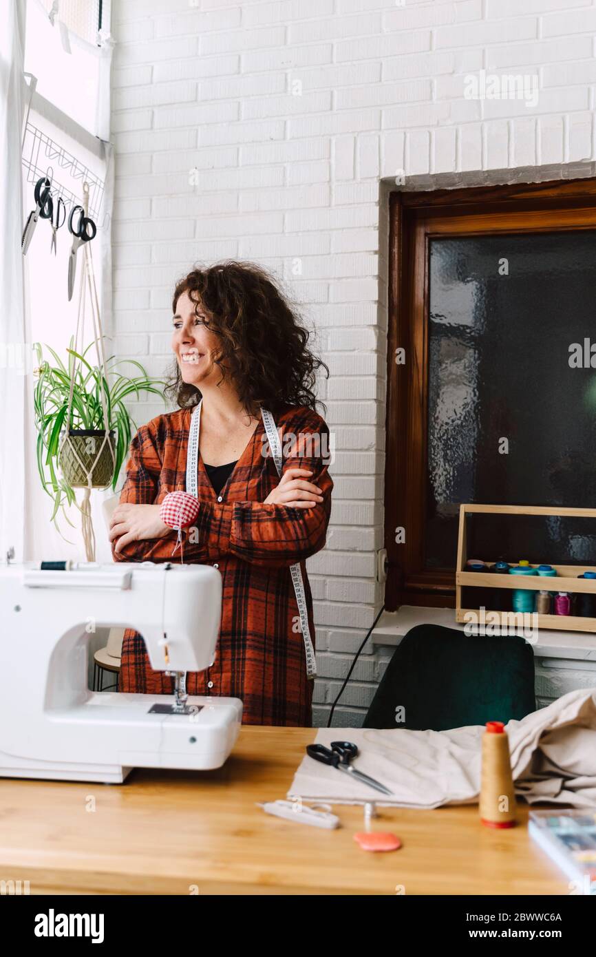 Woman with sewing machine at home looking out of window Stock Photo - Alamy
