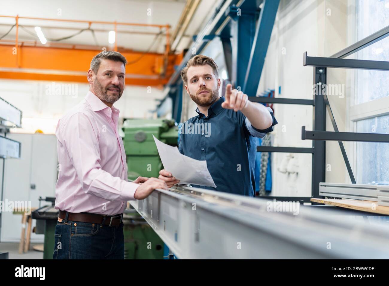 Two men having a work meeting in a factory Stock Photo - Alamy