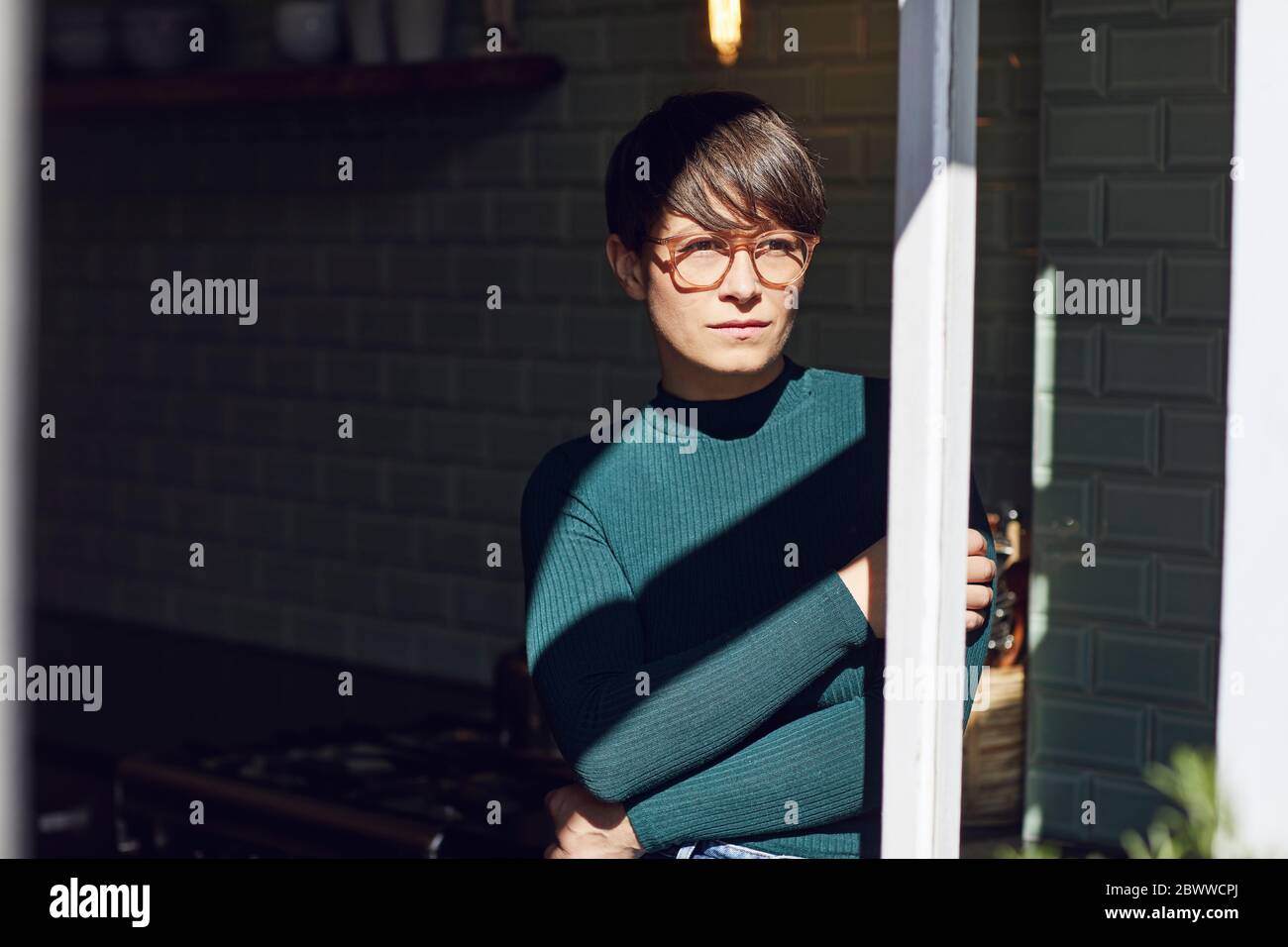 Pensive woman at home looking out of window Stock Photo - Alamy