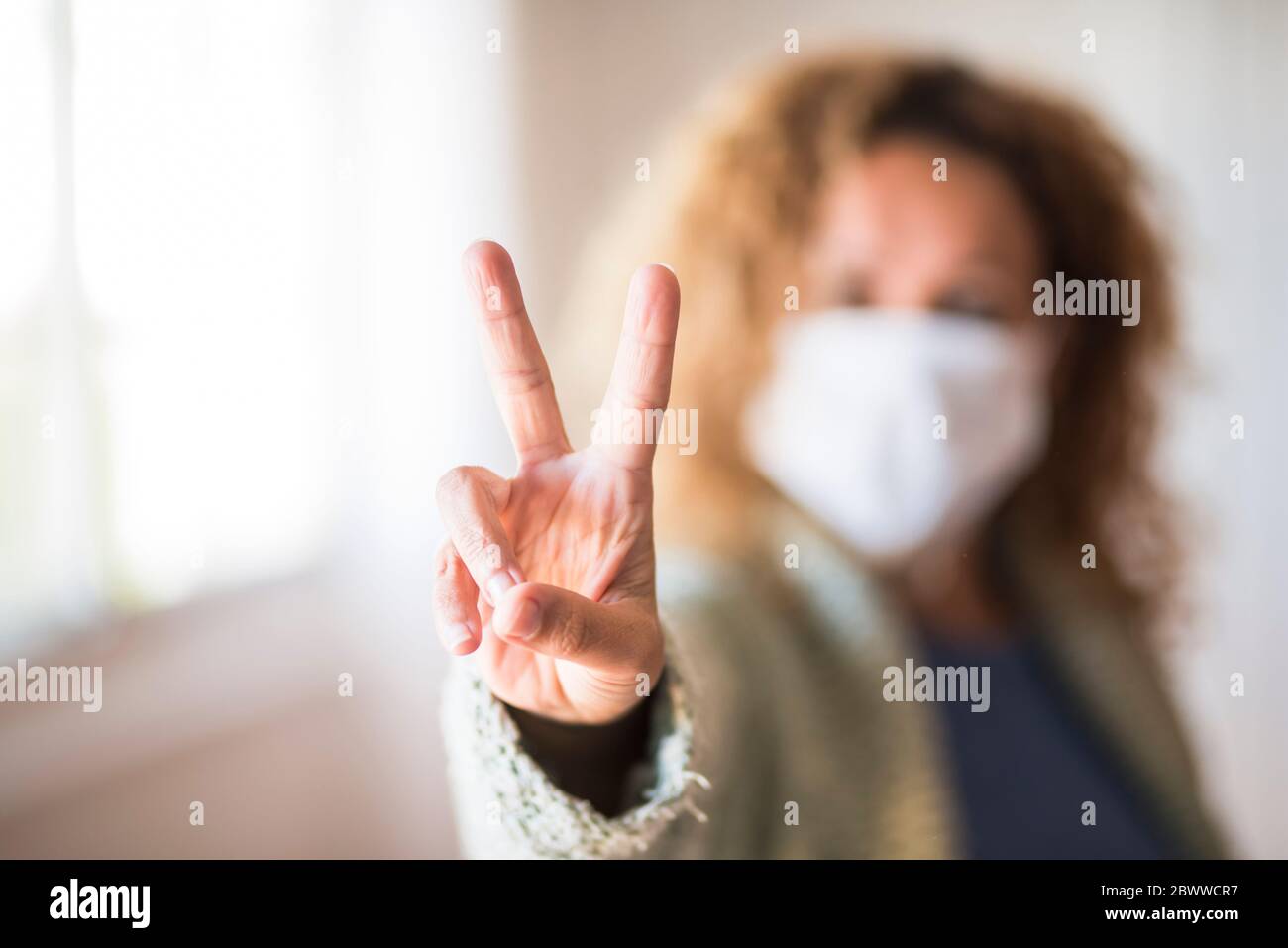 Woman with face mask making victory sign Stock Photo - Alamy