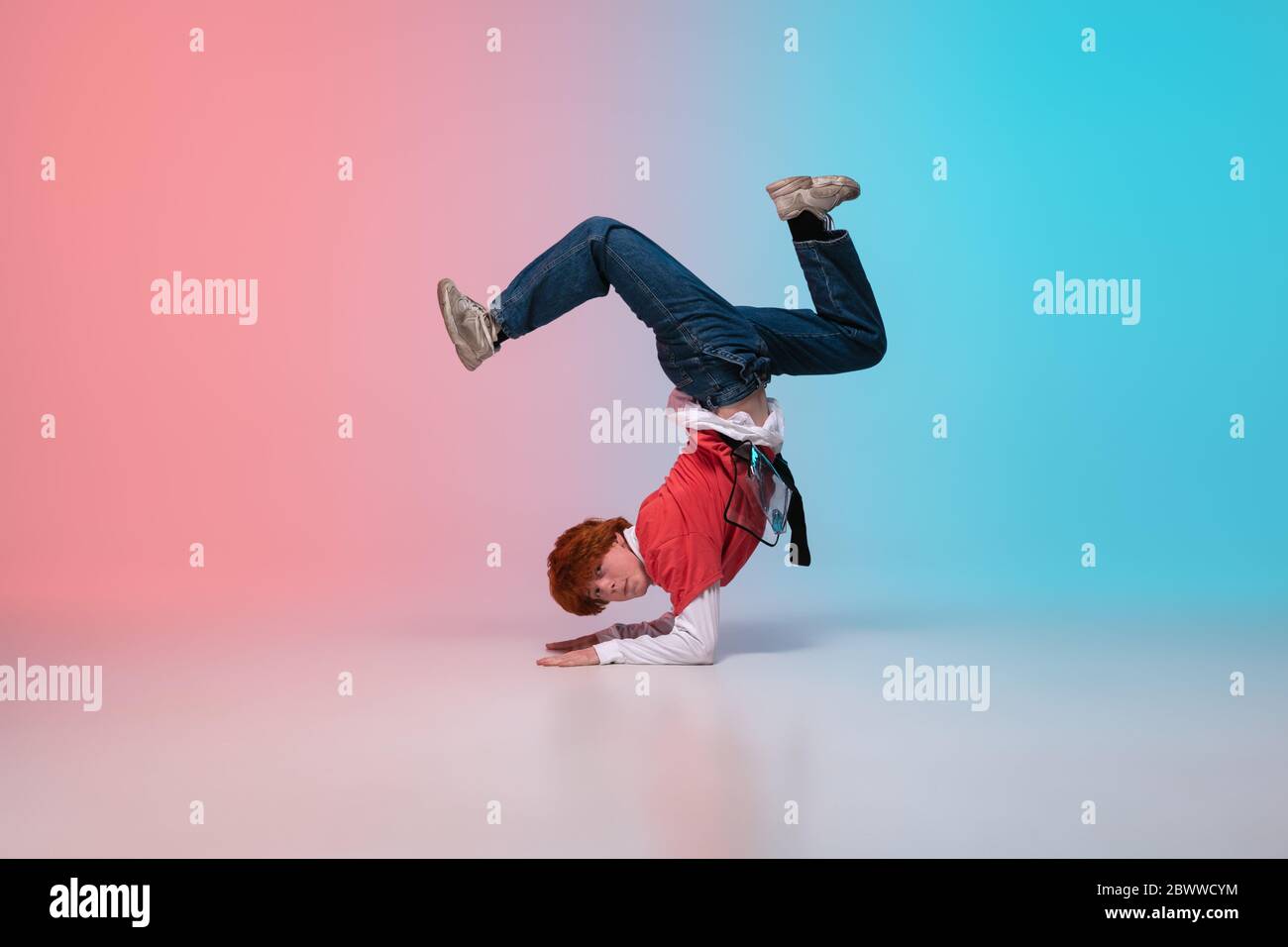 Beautiful sportive boy dancing hip-hop in stylish clothes on colorful ...