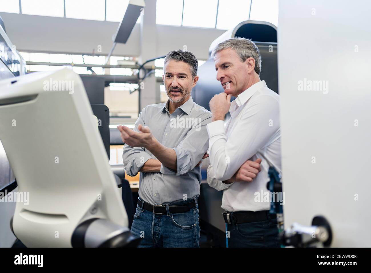 Businessmen in factory, having a meeting, discussing solutions Stock ...