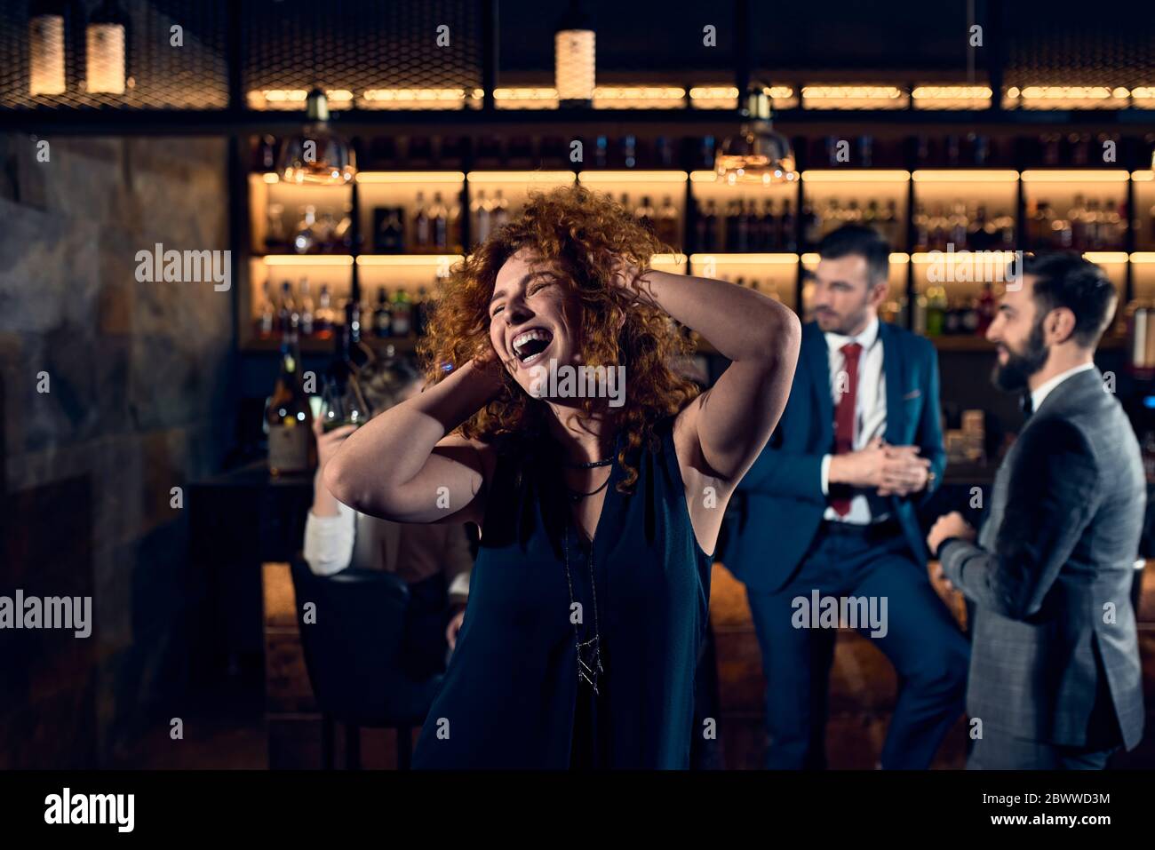 Exuberant young woman with friends dancing in a bar Stock Photo - Alamy