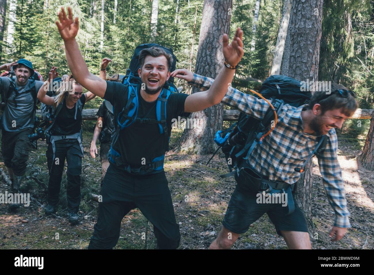 Young people backpacking in nature, laughing and waving at camera Stock ...