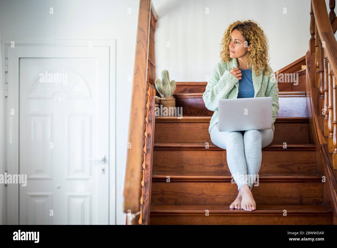 Woman sitting on stairs, using laptop Stock Photo - Alamy