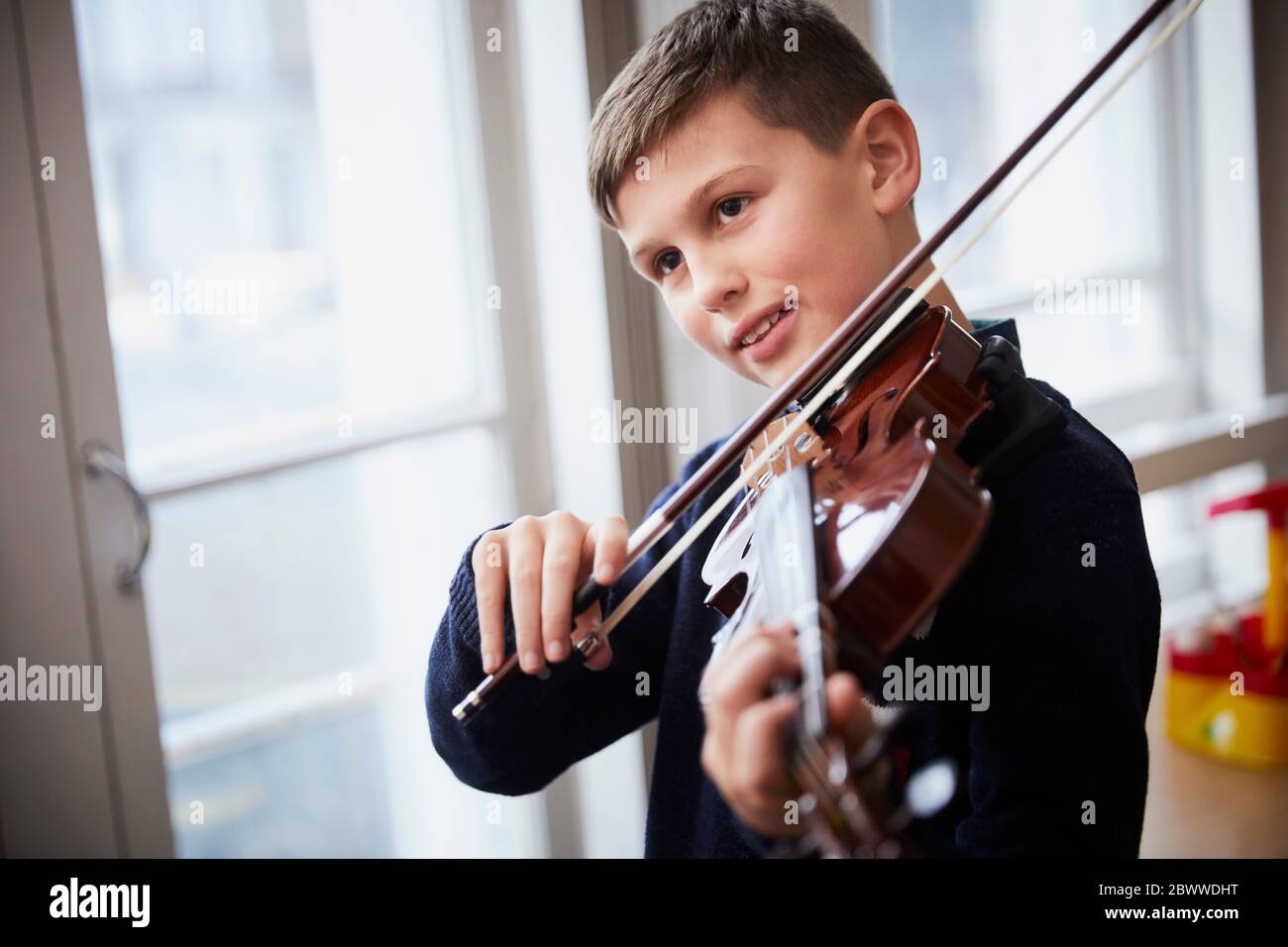 Boy playing violin during a lesson Stock Photo - Alamy