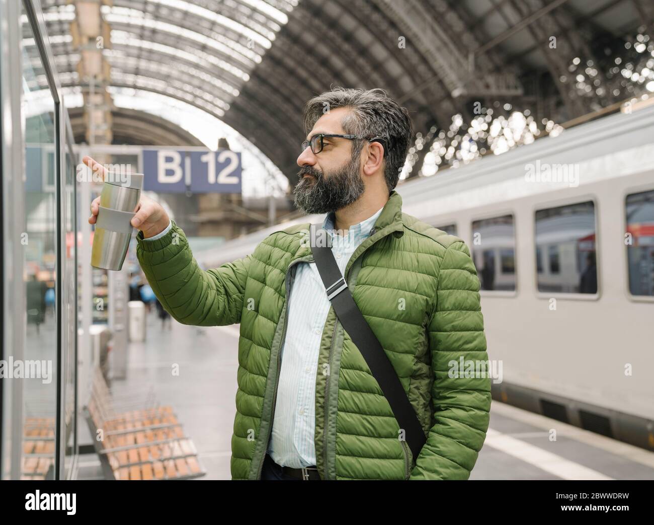 Man checking the timetable at the train station Stock Photo - Alamy