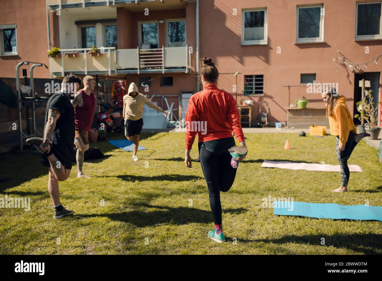 Group of friends doing workout together in garden Stock Photo - Alamy