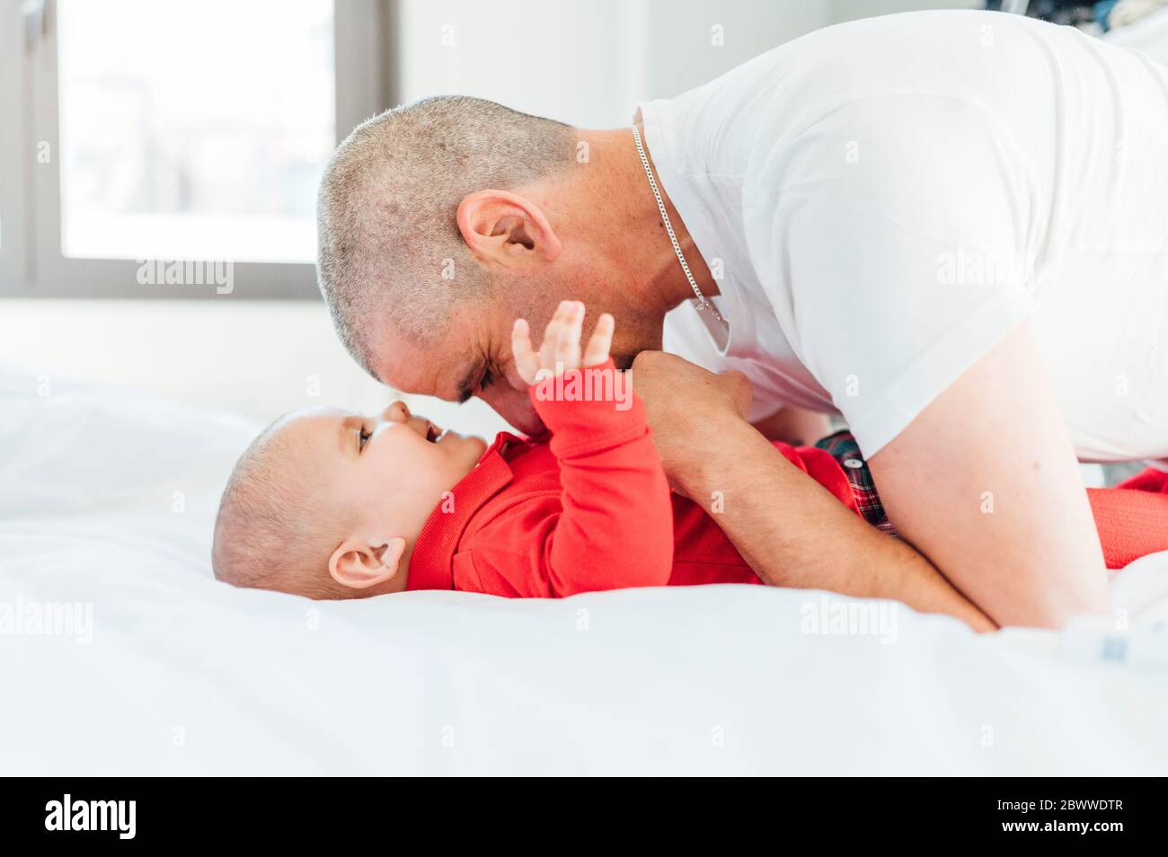 Father cuddling baby boy on bed Stock Photo - Alamy