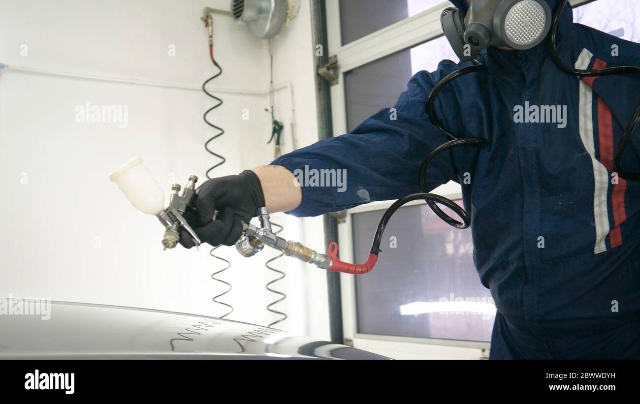 In slow motion, a Man (Man) professional in working uniform with spray ...