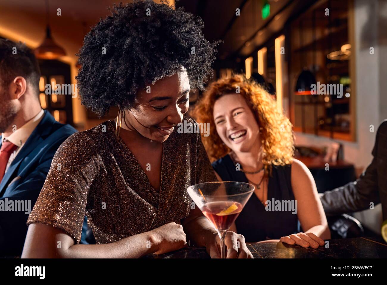 Cheerful friends socializing in a bar Stock Photo - Alamy