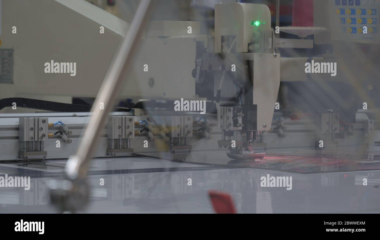 Industrial garment factory, an automatic sewing machine sews various ...