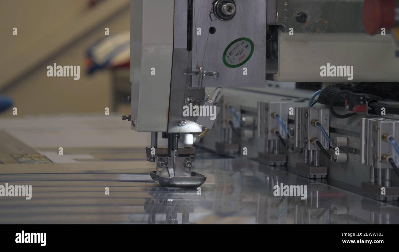 Industrial garment factory, an automatic sewing machine sews various ...