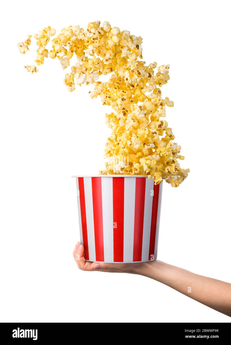 Woman hand holding striped bucket with flying popcorn isolated on white ...