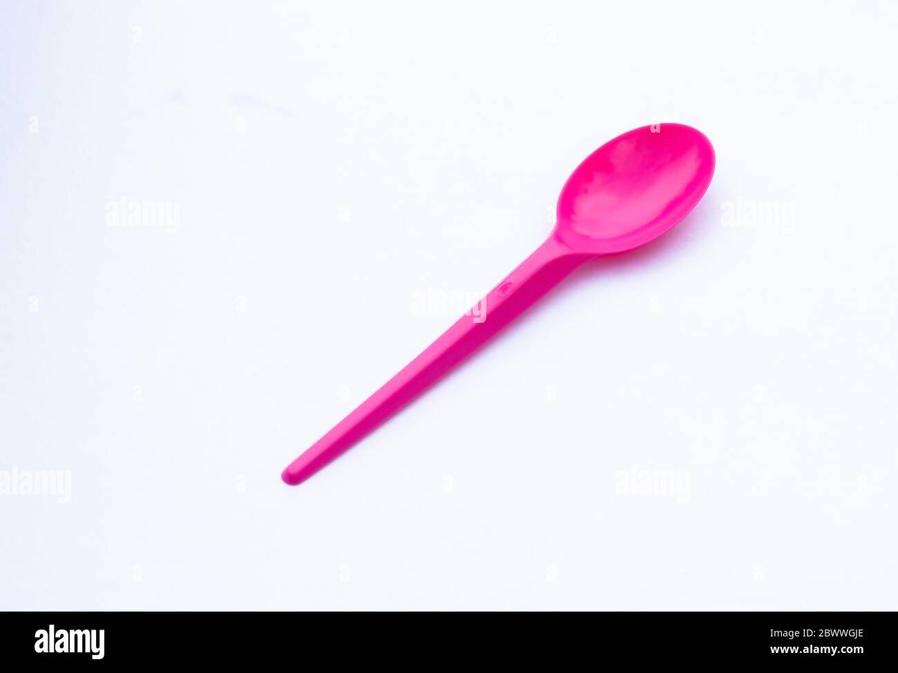 one vibrant pink plastic spoon isolated on white Stock Photo - Alamy