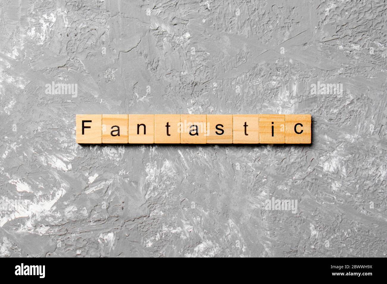 fantastic word written on wood block. fantastic text on cement table ...