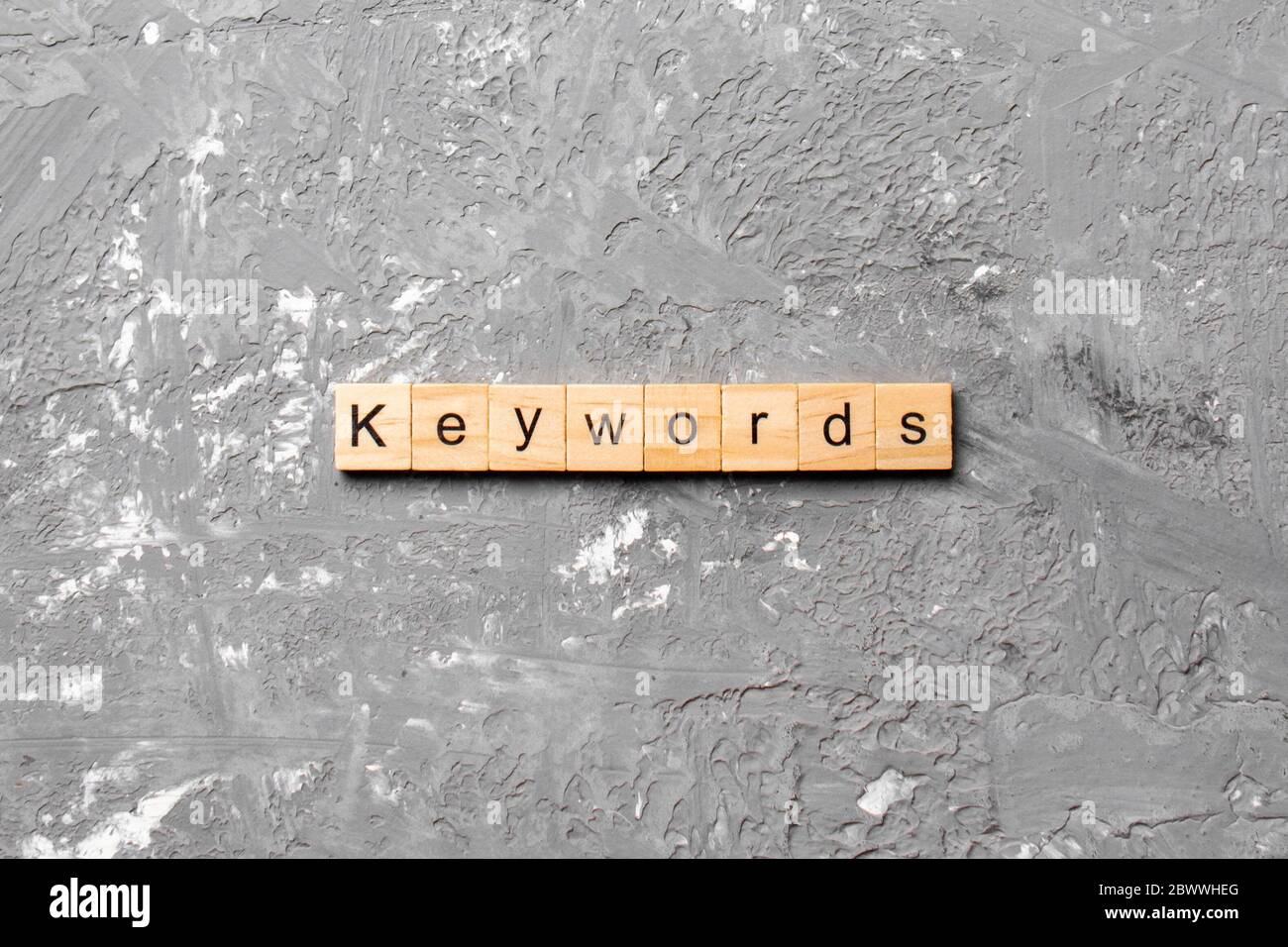 KEYWORDS word written on wood block. KEYWORDS text on cement table for ...