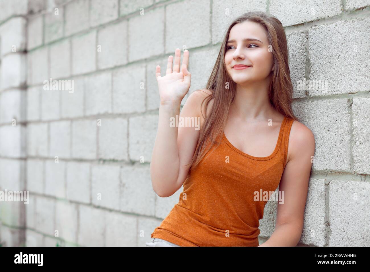 Hi dear, greeting someone. Happy smiling woman waving hand waving over ...
