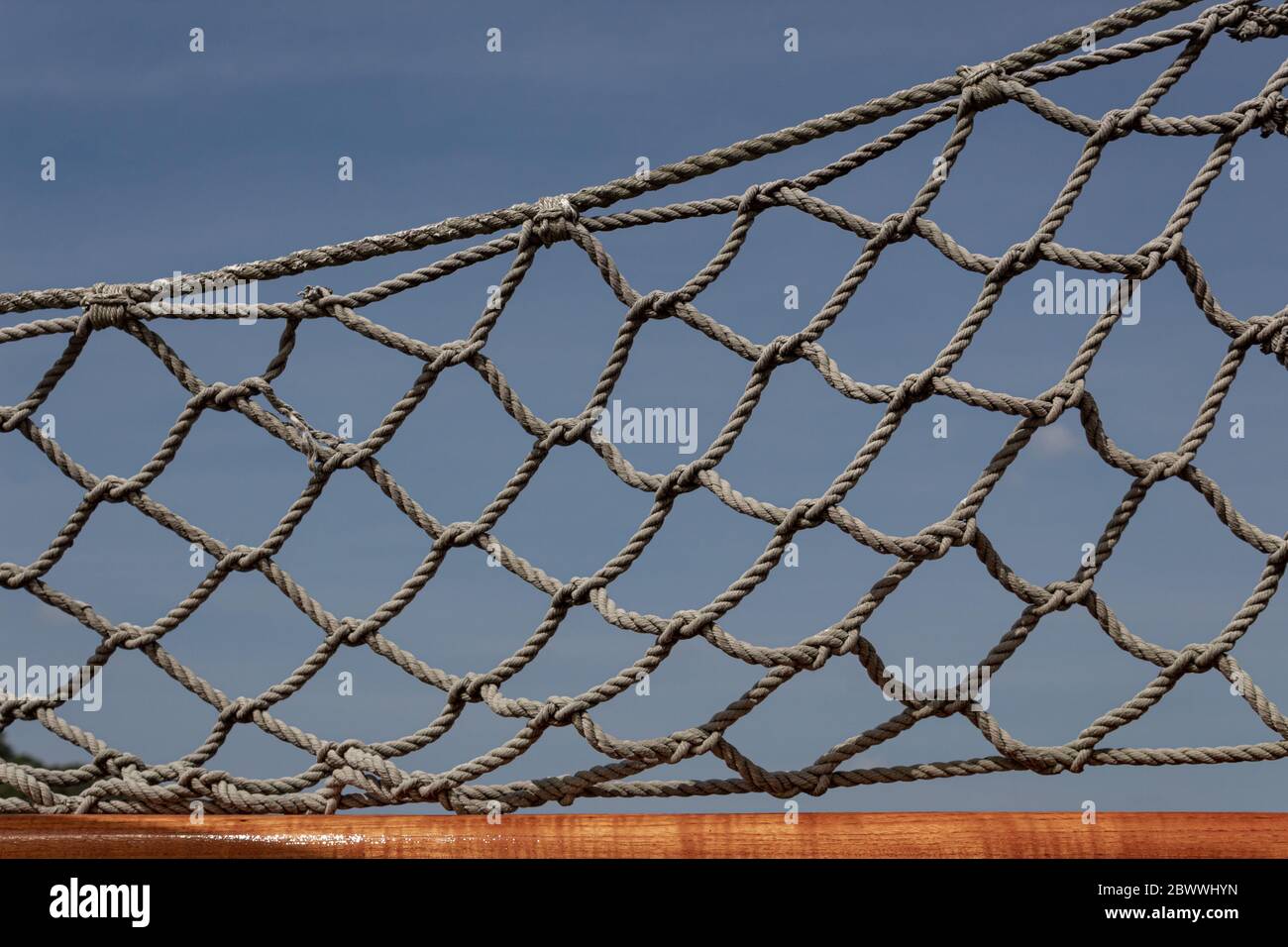 Rope net on a vintage sailing vessel against a blue sky, horizontal ...