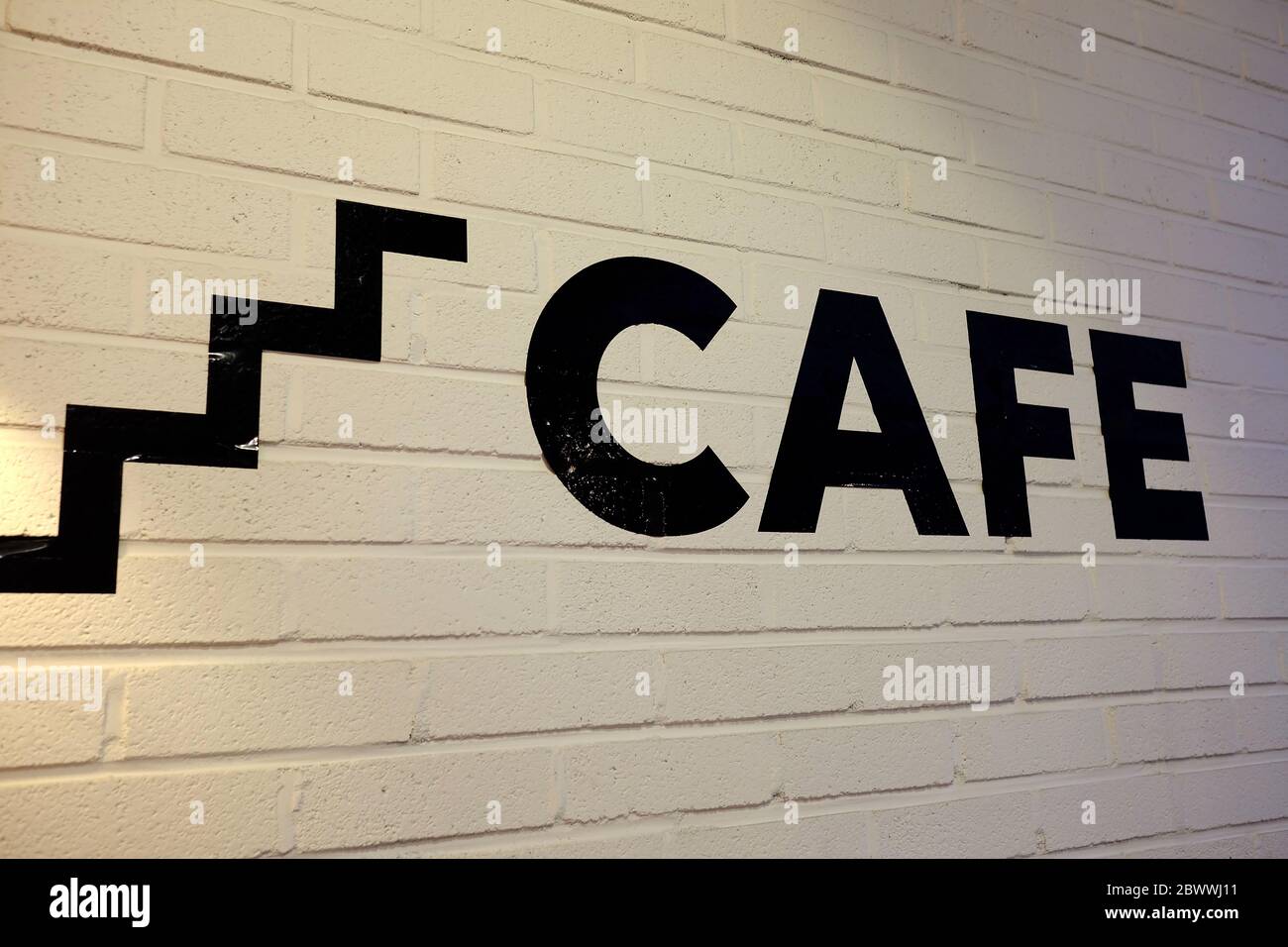 Cafe Sign Direction on White Brick Wall Stock Photo - Alamy